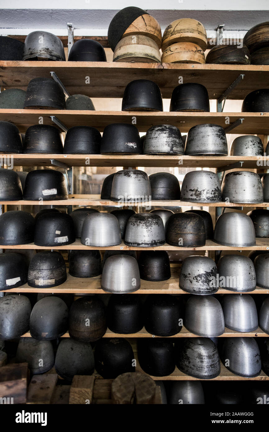 Various hat shaped equipment on shelves in workshop Stock Photo - Alamy