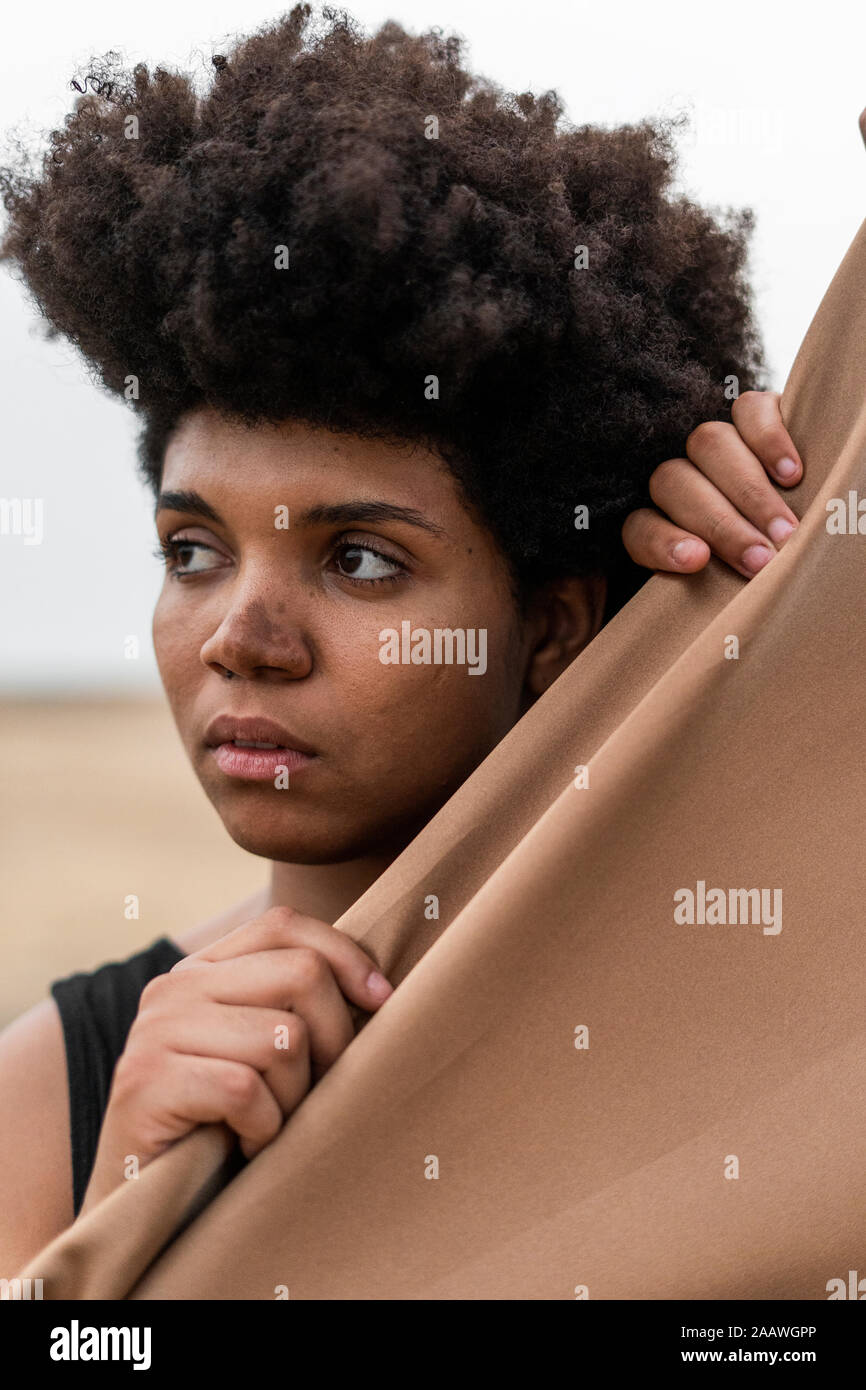 Portrait of young woman behind cloth looking at distance Stock Photo ...