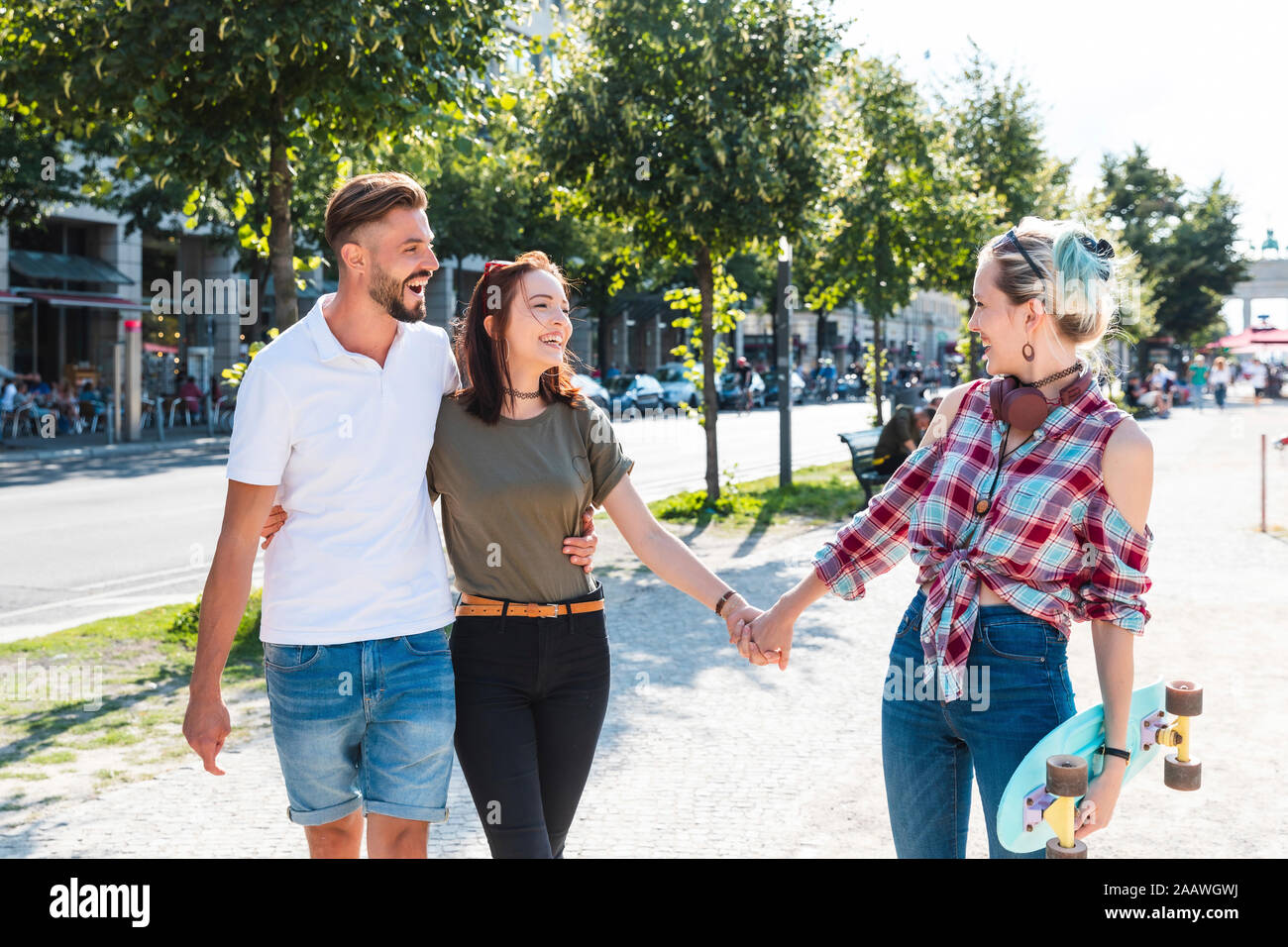 Three friends strolling together having fun Stock Photo - Alamy