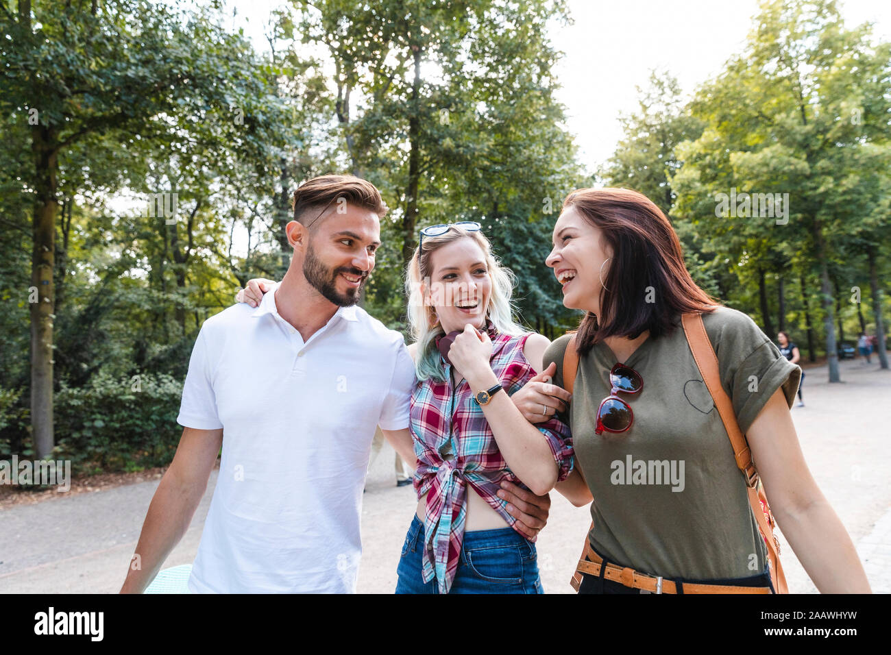 Group of three friends strolling together in a park having fun Stock ...