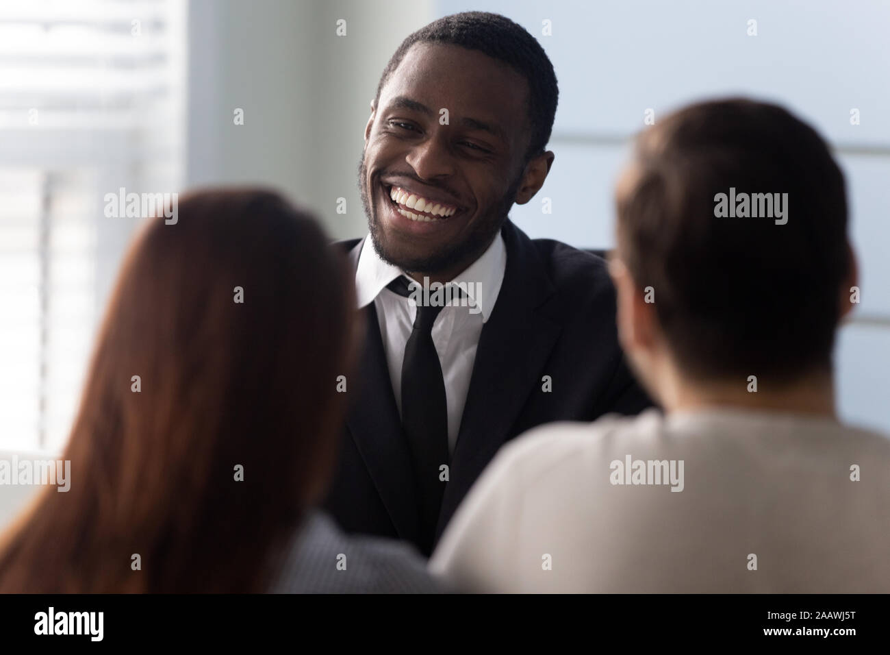 Smiling african American agent talk with clients Stock Photo - Alamy