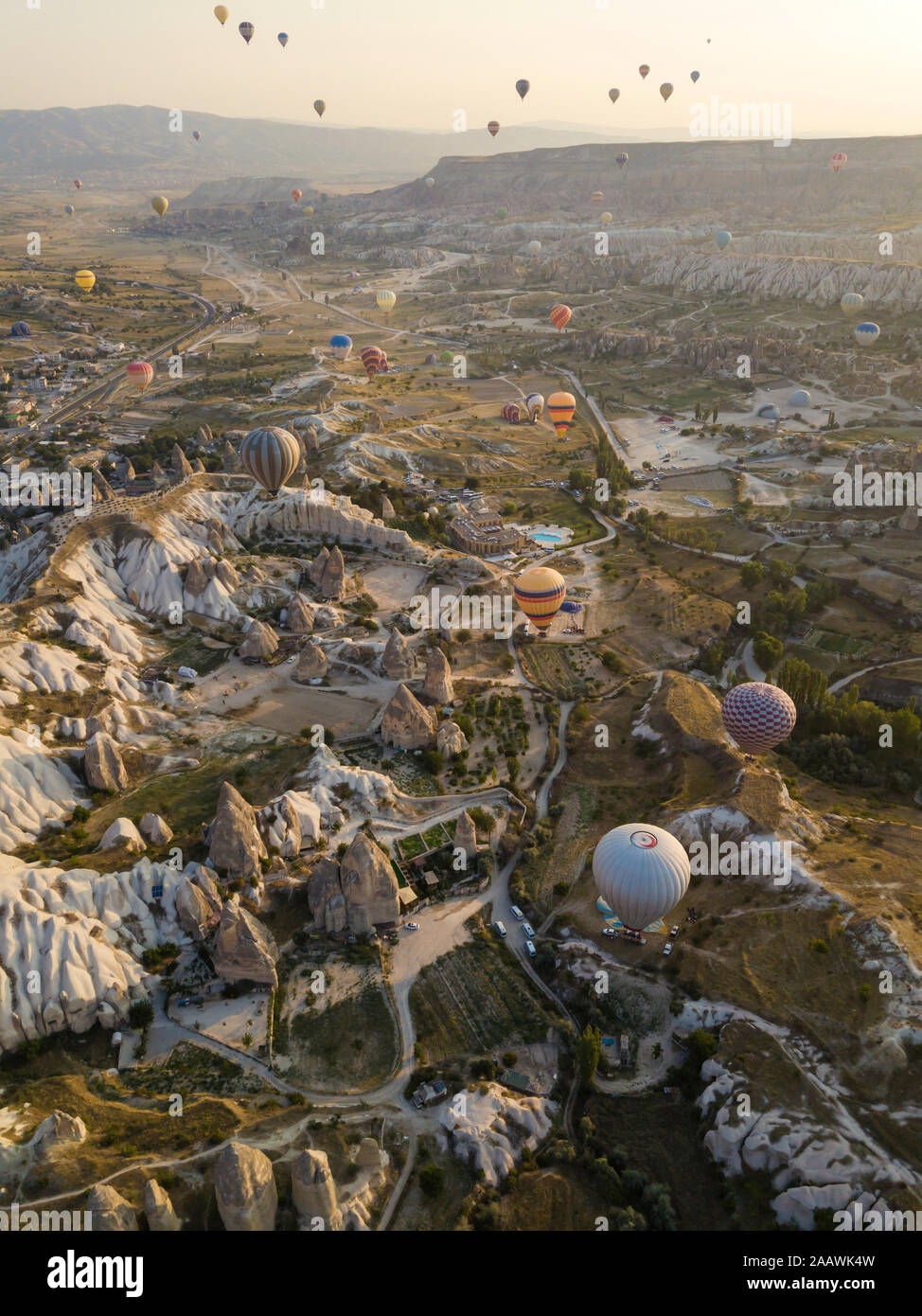 Aerial view of colorful hot air balloons flying over land at Goreme ...