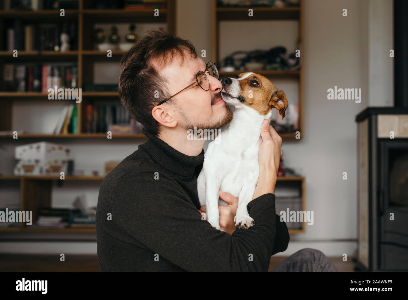 Young man with Jack Russel Terrier, licking Stock Photo - Alamy