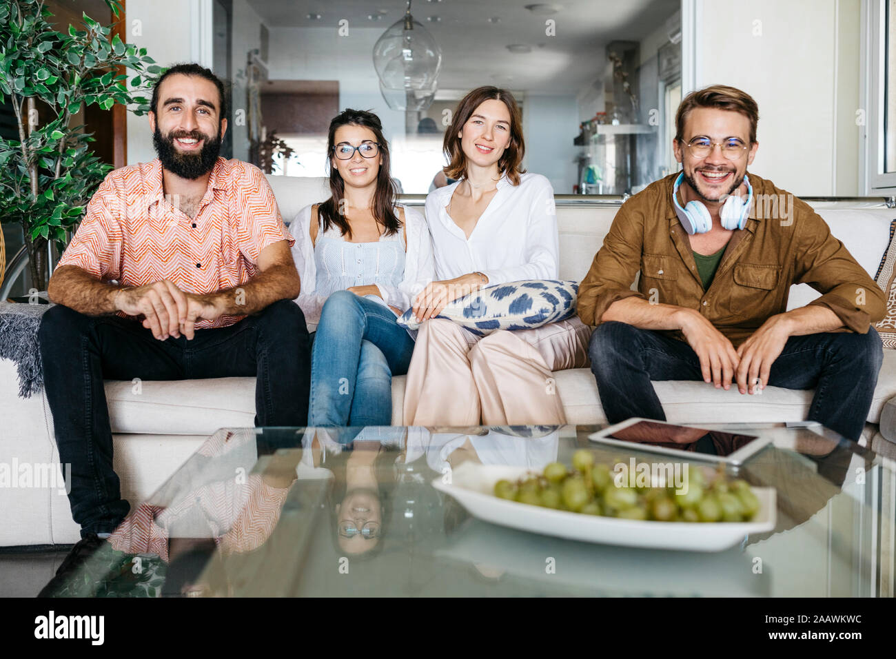 Portrait of happy friends sitting on couch together Stock Photo - Alamy