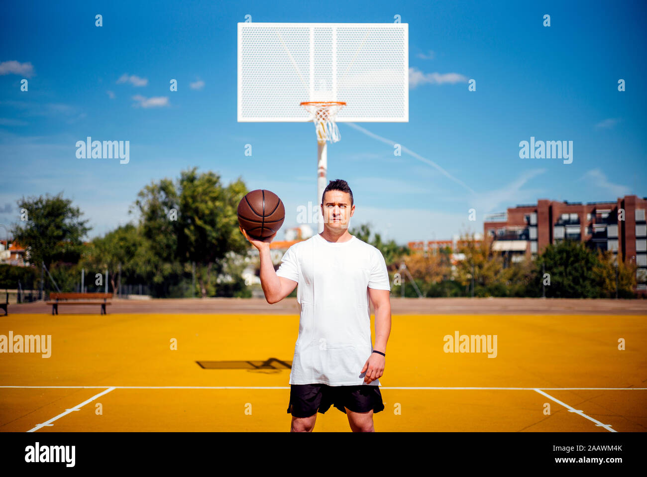 Basketball player posing at camera with the ball Stock Photo - Alamy