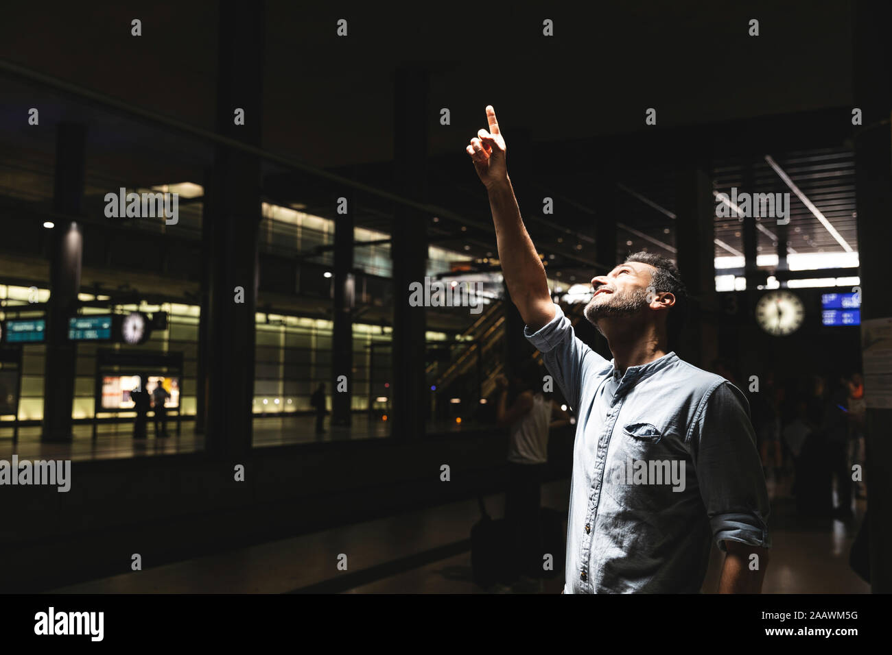 Man at the station in shadow looking up and pointing his finger, Berlin ...