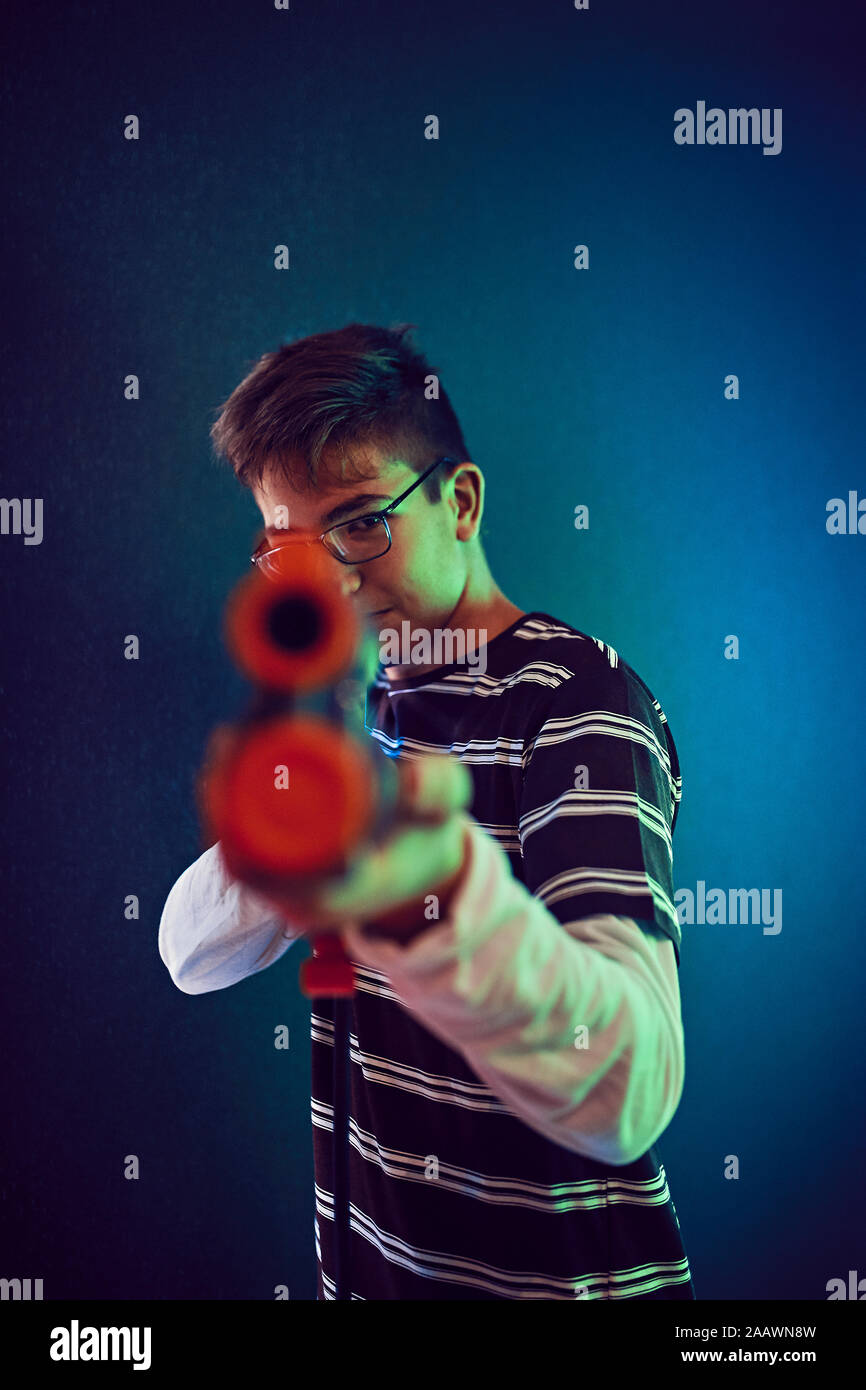 Teenage boy shooting with gun in an amusement arcade Stock Photo - Alamy
