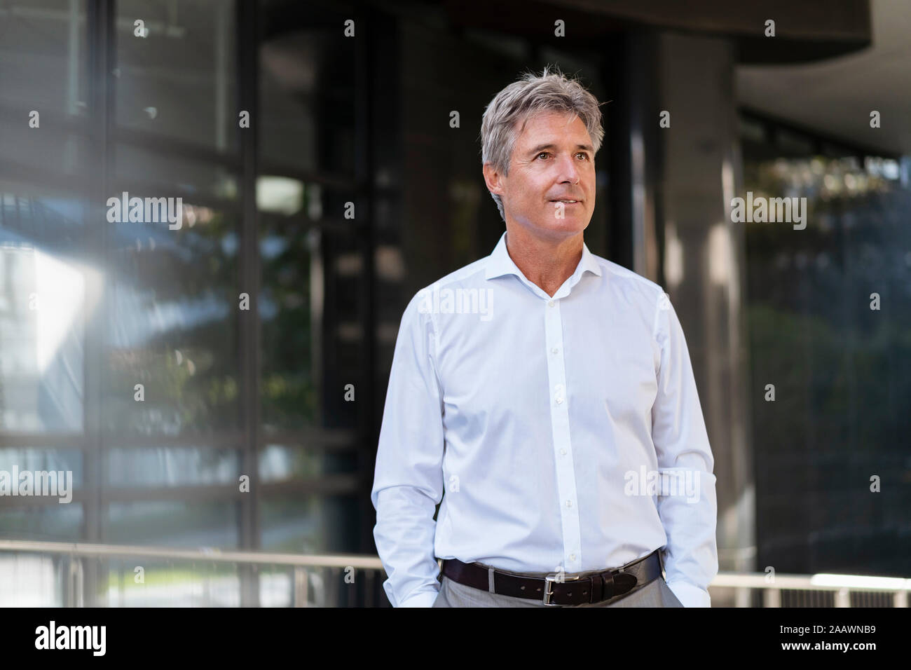 Mature businessman outside an office building looking around Stock ...