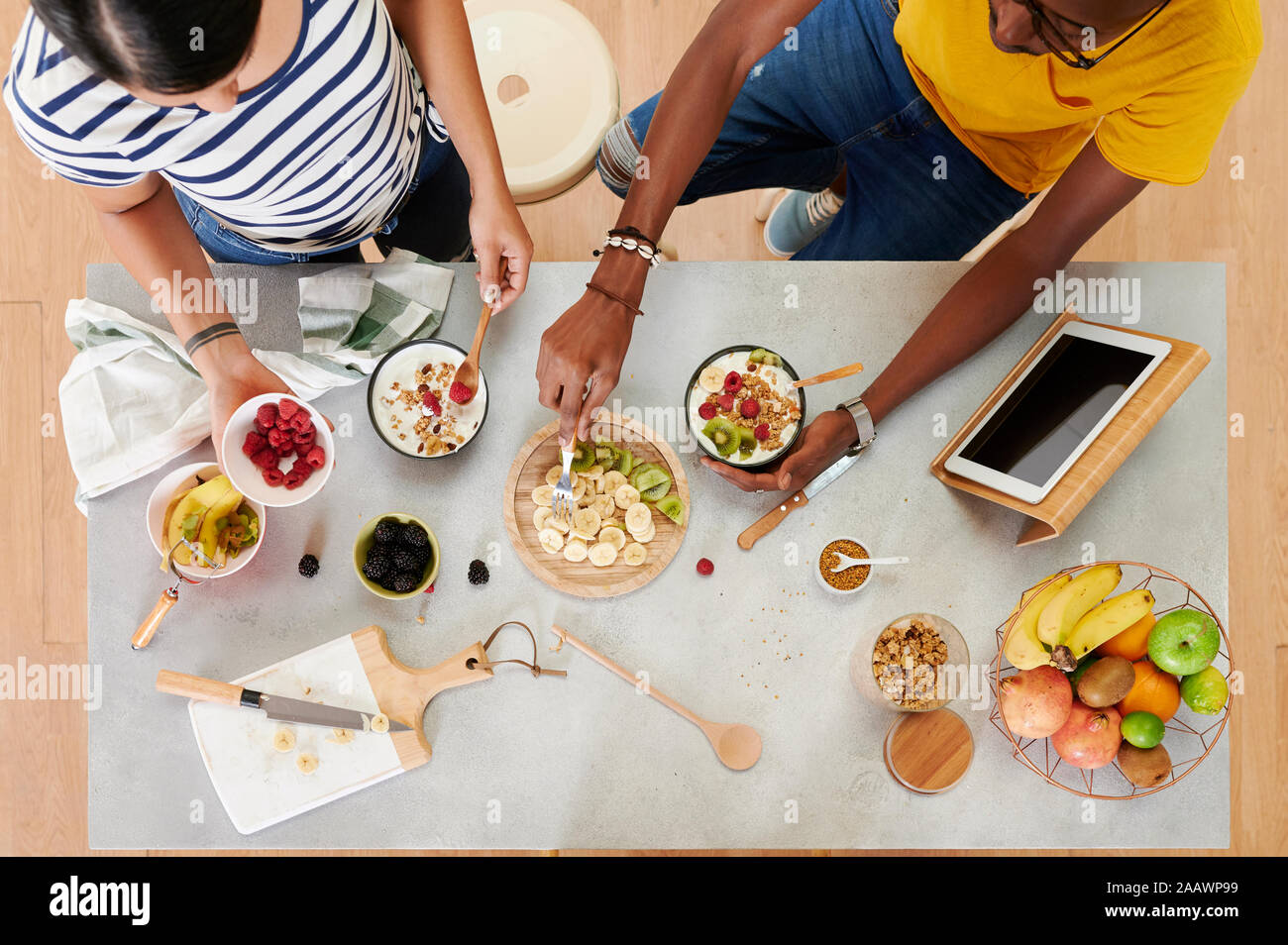 Multiethnic couple breakfasting together in the kitchen, from above ...