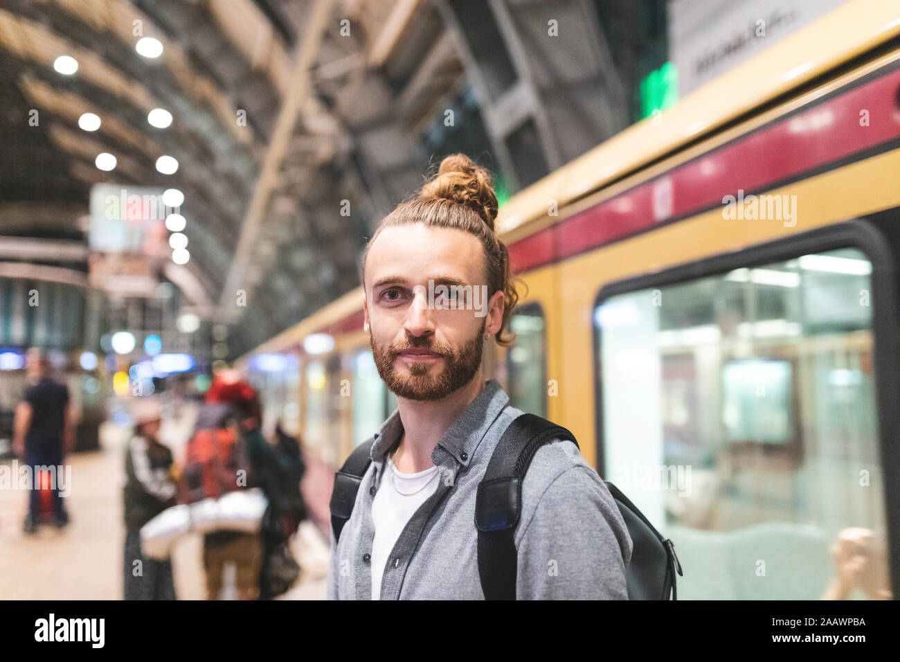 Young man waiting on train station Stock Photo - Alamy