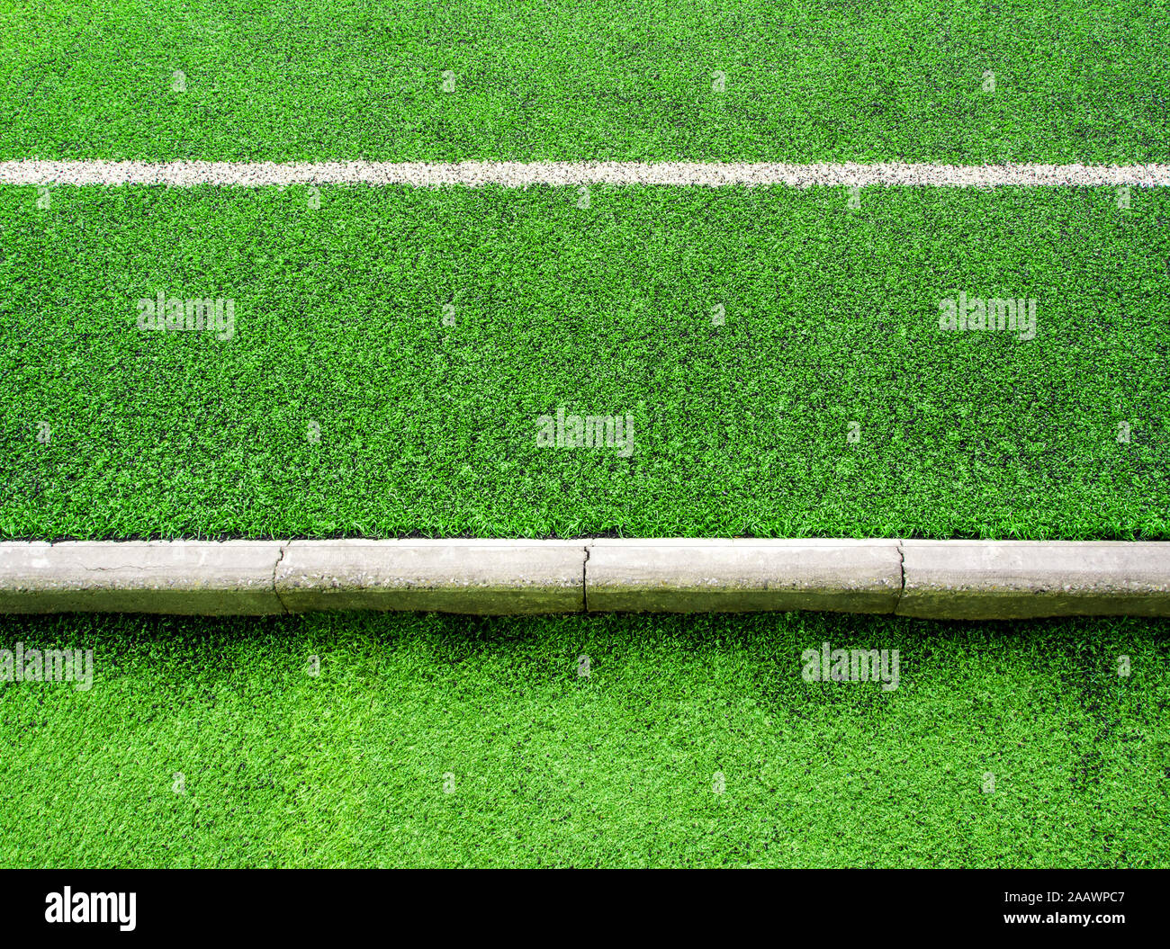 White line on plastic artificial grass and the concrete border of ...