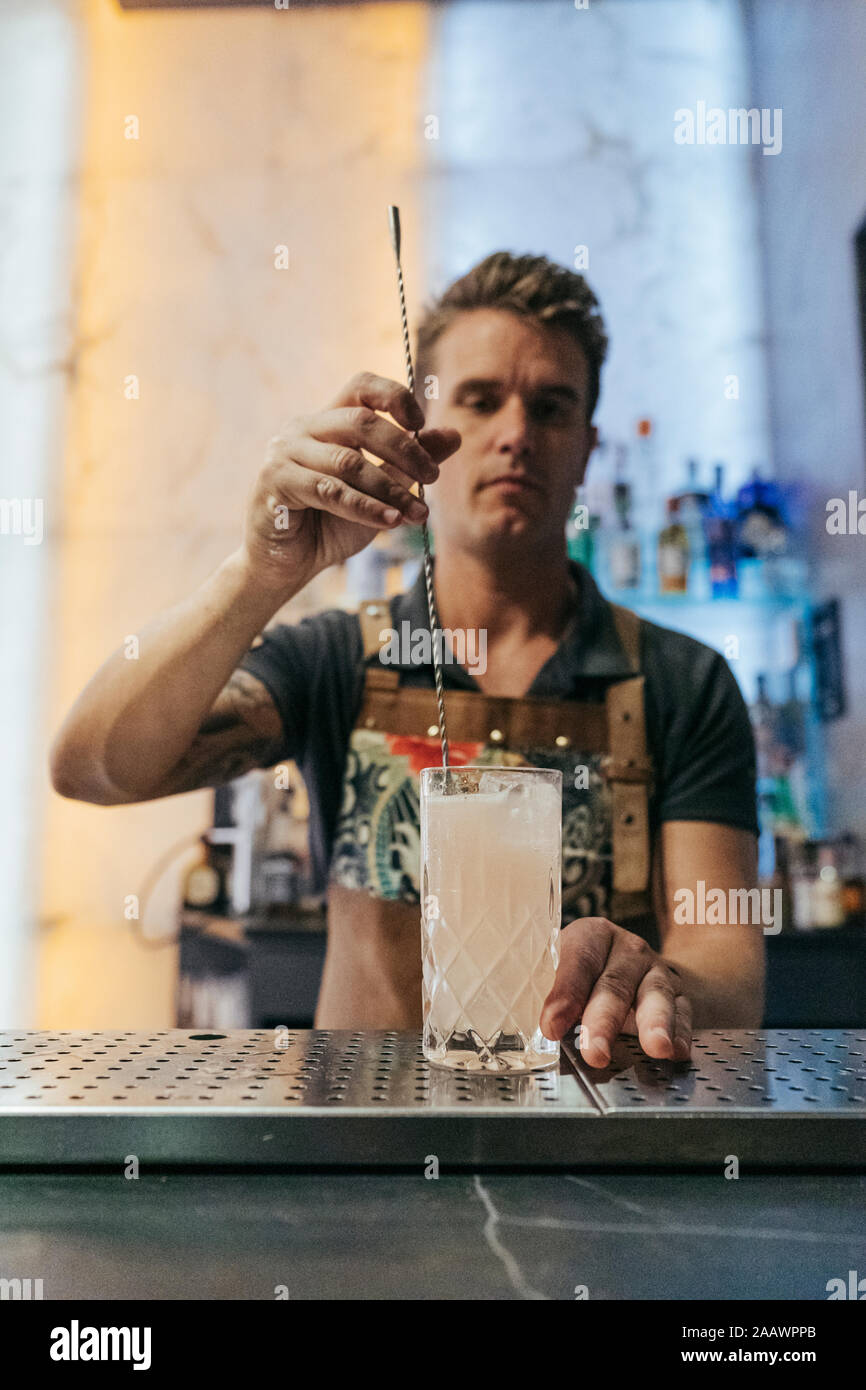 Bartender mixing cocktail in a bar, using bar spoon Stock Photo - Alamy