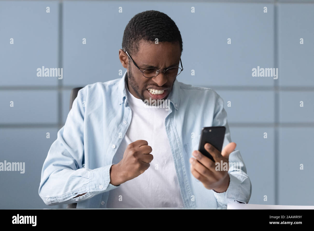 Mad biracial man get angry having cellphone problems Stock Photo - Alamy