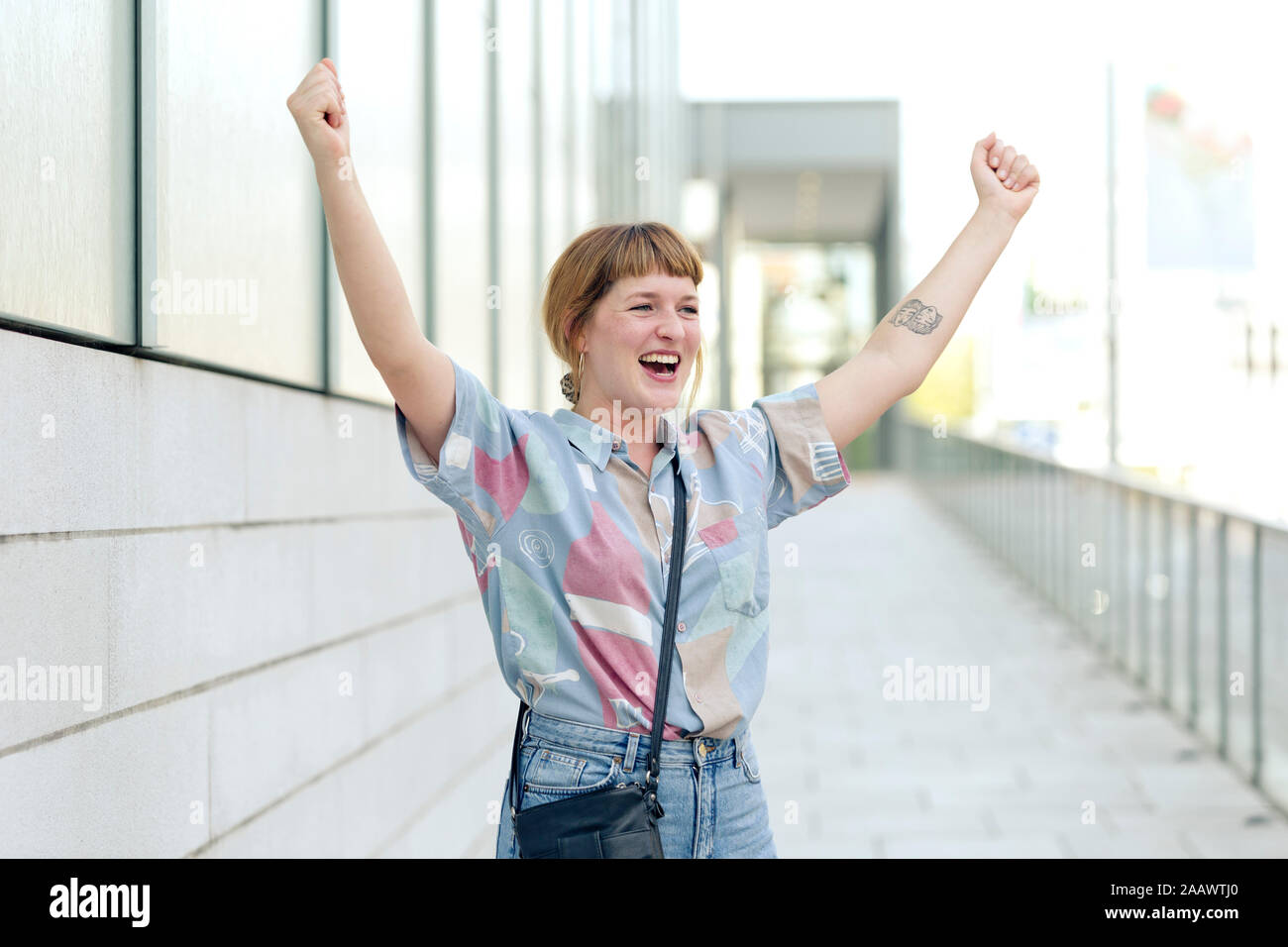 Portrait of happy young woman raising hands Stock Photo - Alamy
