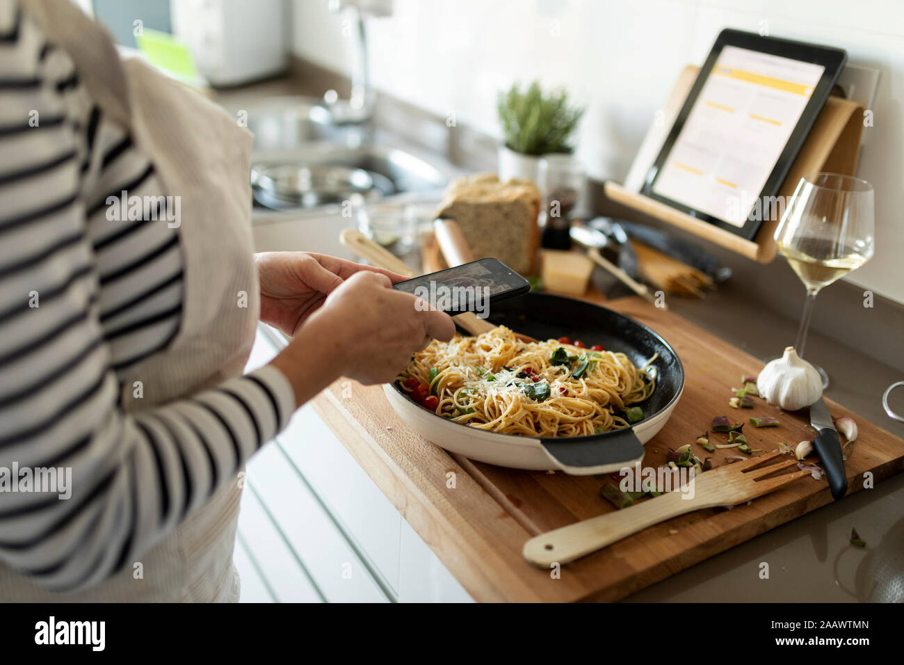Close-up of woman taking smartphone picture of her pasta dish in ...