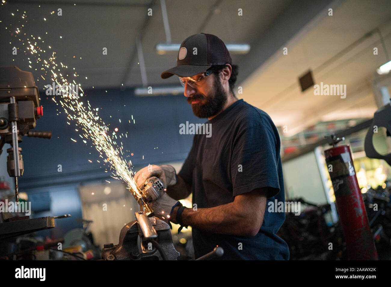 Mechanic in a repair garage working with a grinder Stock Photo - Alamy