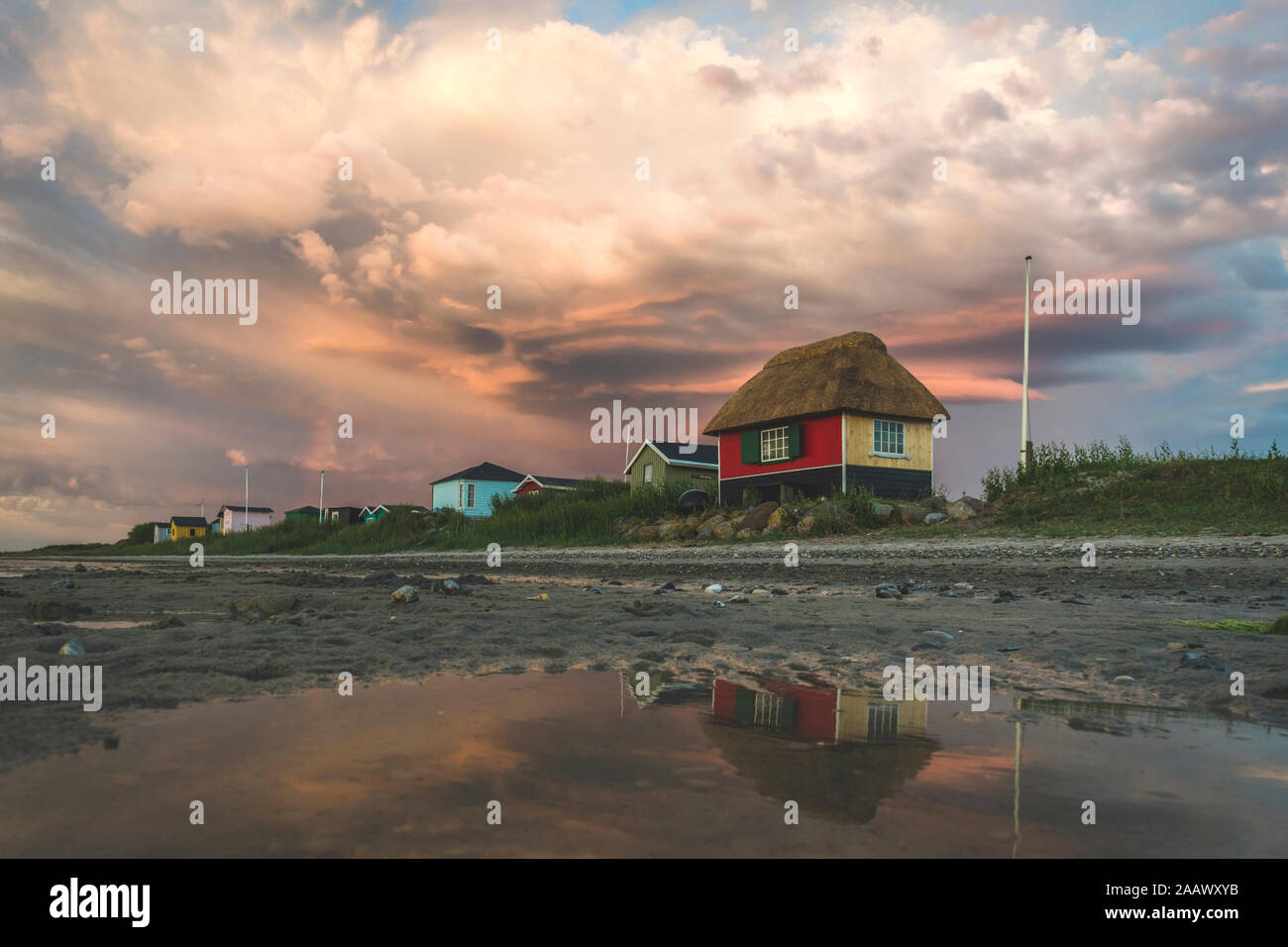 Denmark, Aeroe, Marstal, Storm clouds over traditional baths seen at ...