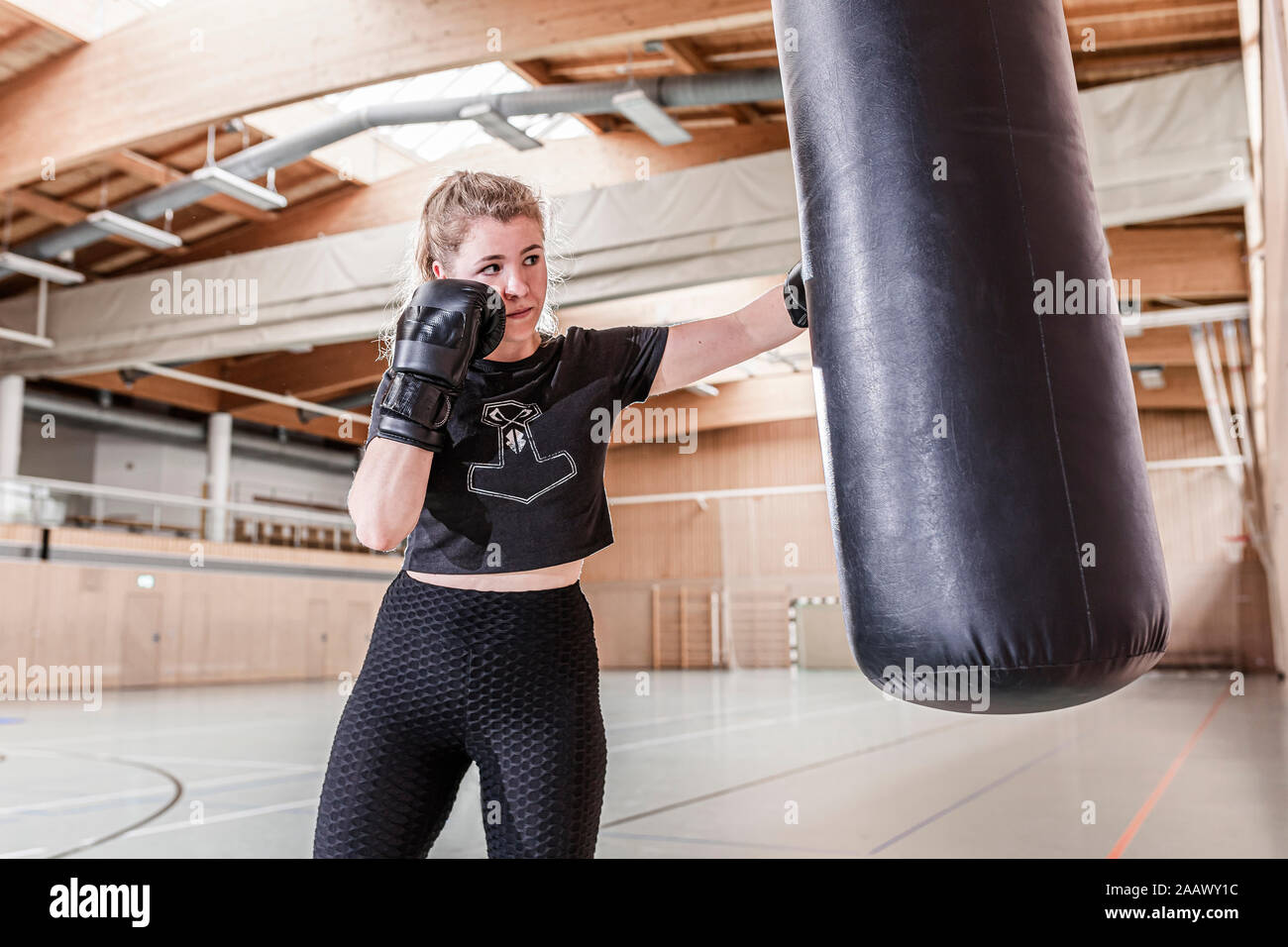 Female boxer practising at punchbag in sports hall Stock Photo - Alamy