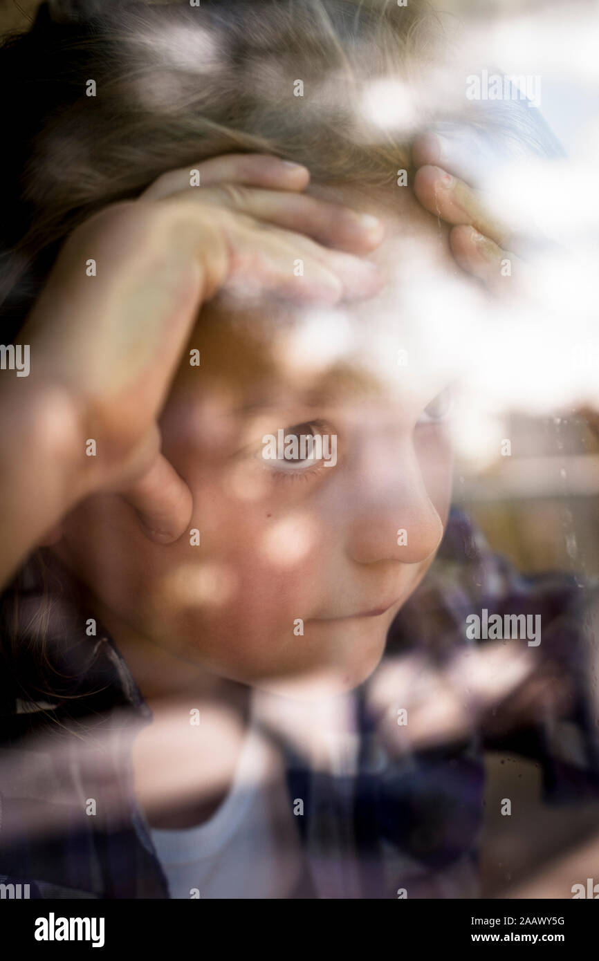 Portrait of girl looking through window Stock Photo - Alamy