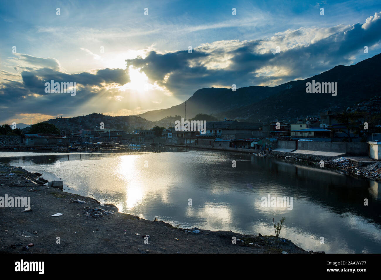 Sun streaming through clouds over Cap Haitien at sunset, Haiti ...