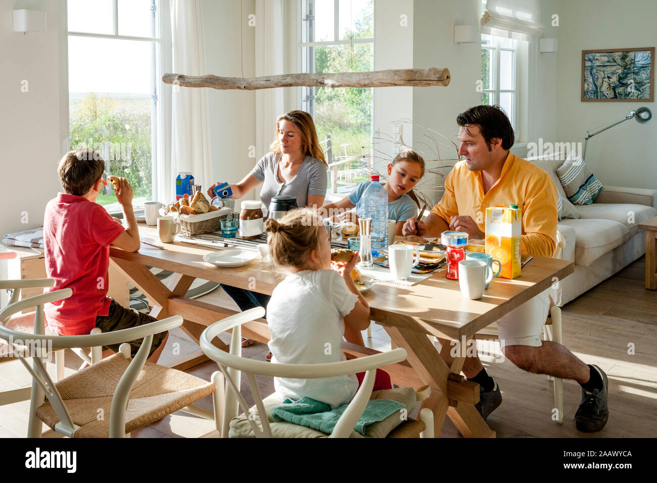 Family having breakfast at dining table Stock Photo - Alamy