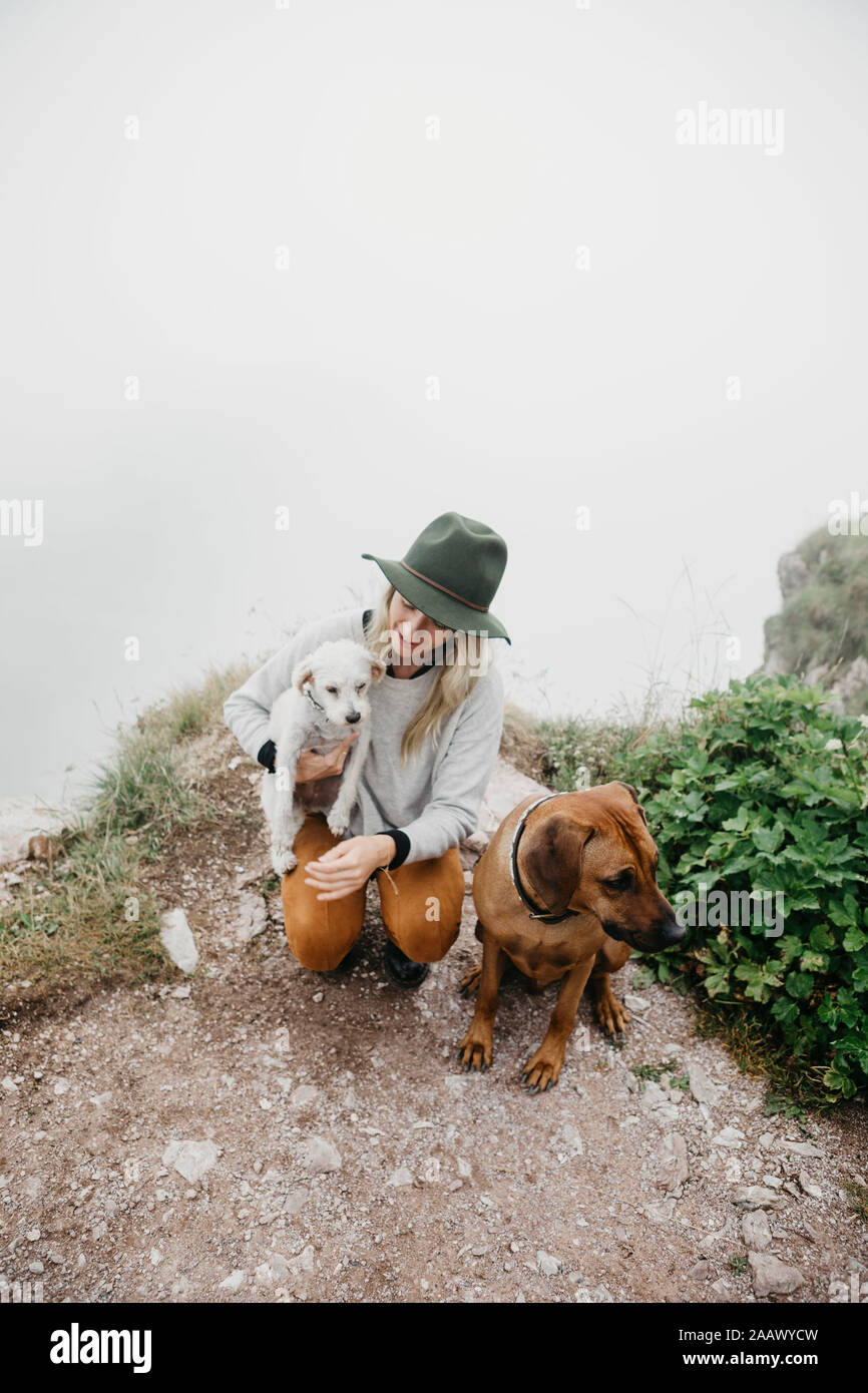 Young woman with two dogs on viewpoint Stock Photo - Alamy