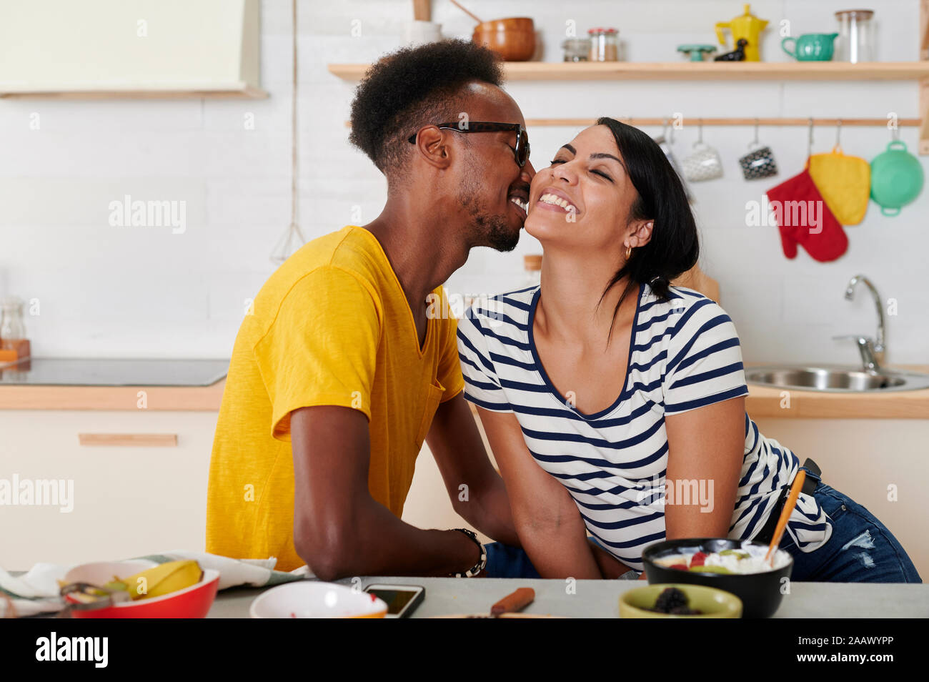 Multiethnic couple breakfasting together in the kitchen Stock Photo - Alamy