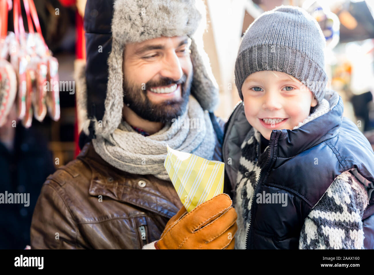 Father and son eating sweets on Christmas Market Stock Photo - Alamy