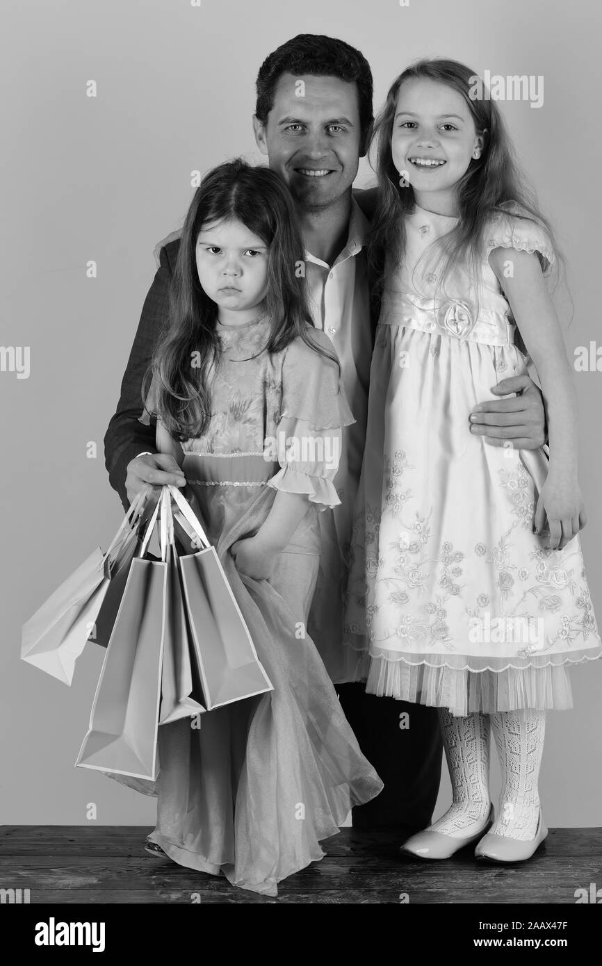 Schoolgirls and father hold pink packets. Girls and man with smiling ...