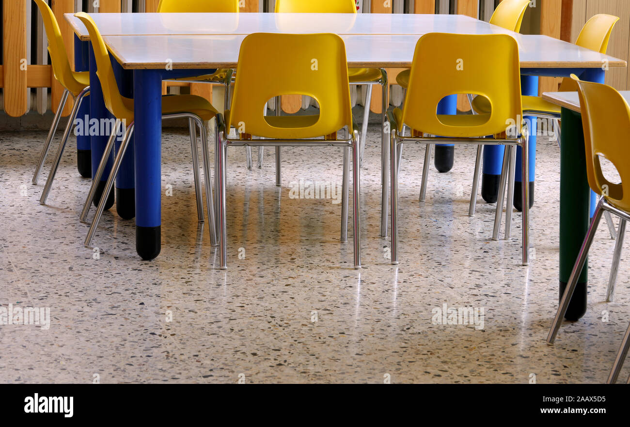 yellow small chairs and tables in the classroom of the school wihtout ...