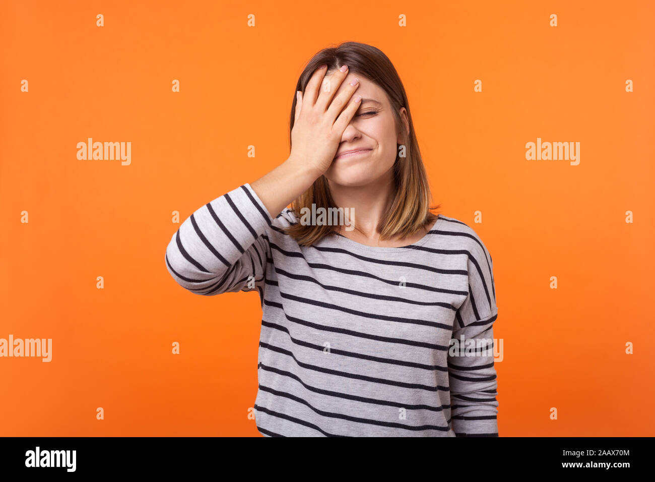 Facepalm. Portrait of forgetful upset woman with brown hair in long ...