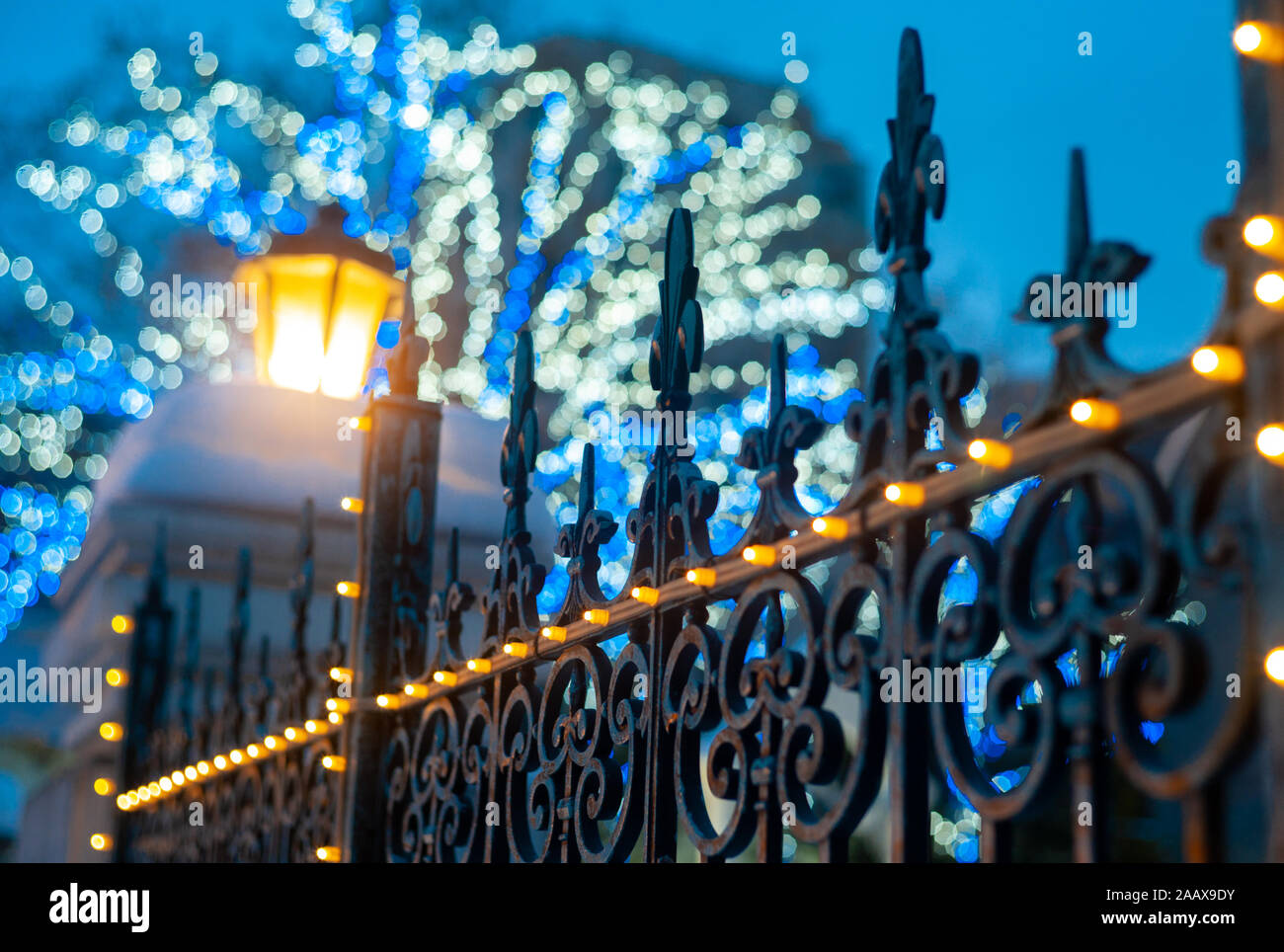 Iron fleur de lis, French lily fence and yellow lantern with blue bokeh ...