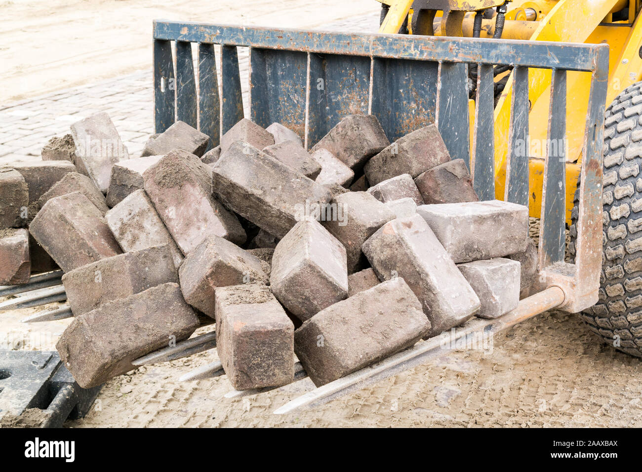 Pile of bricks on sieve scoop of small excavator Stock Photo - Alamy