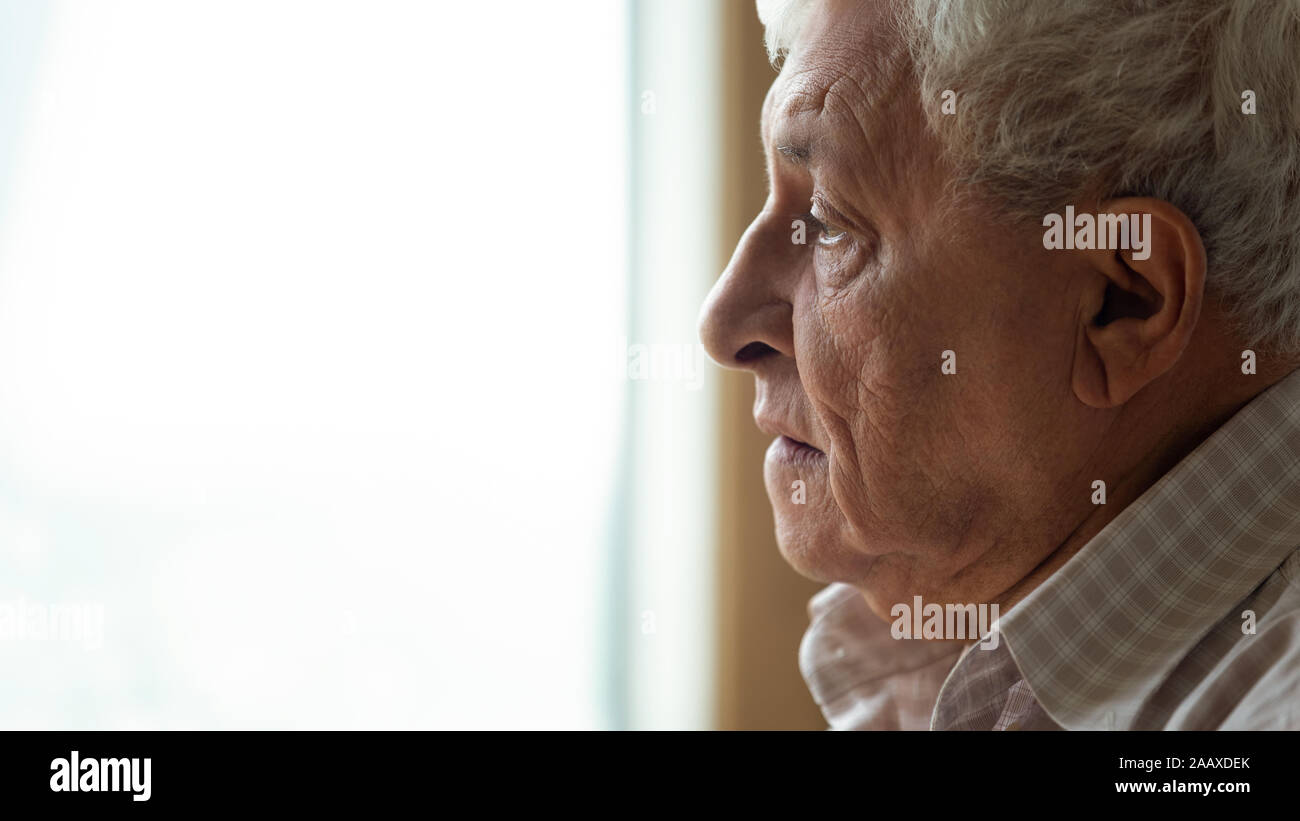 Pensive older man looking out of window, recollecting memories Stock ...
