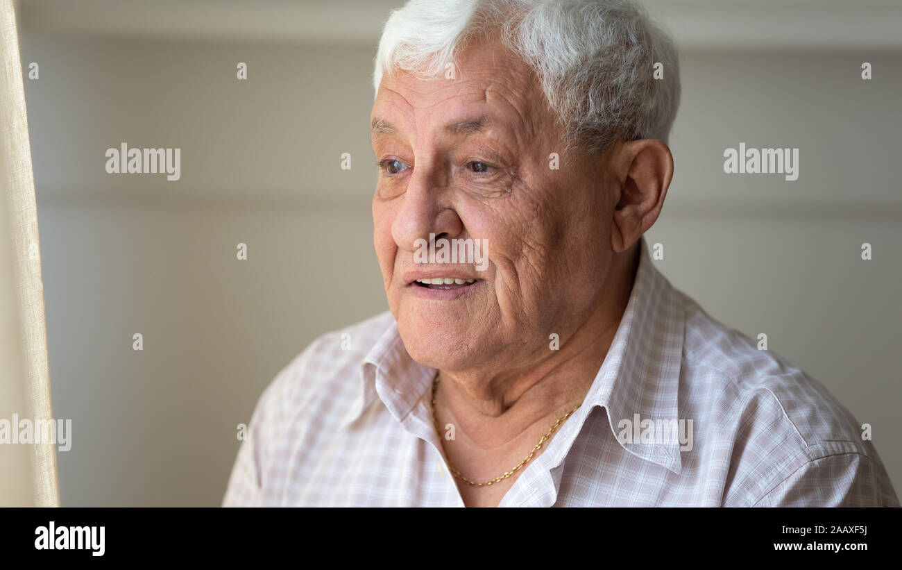 Happy older retired man looking with hope out of window Stock Photo - Alamy