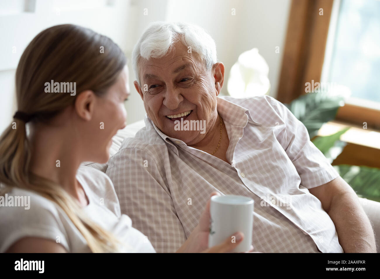 Happy old man talking with smiling grown up adult daughter Stock Photo ...