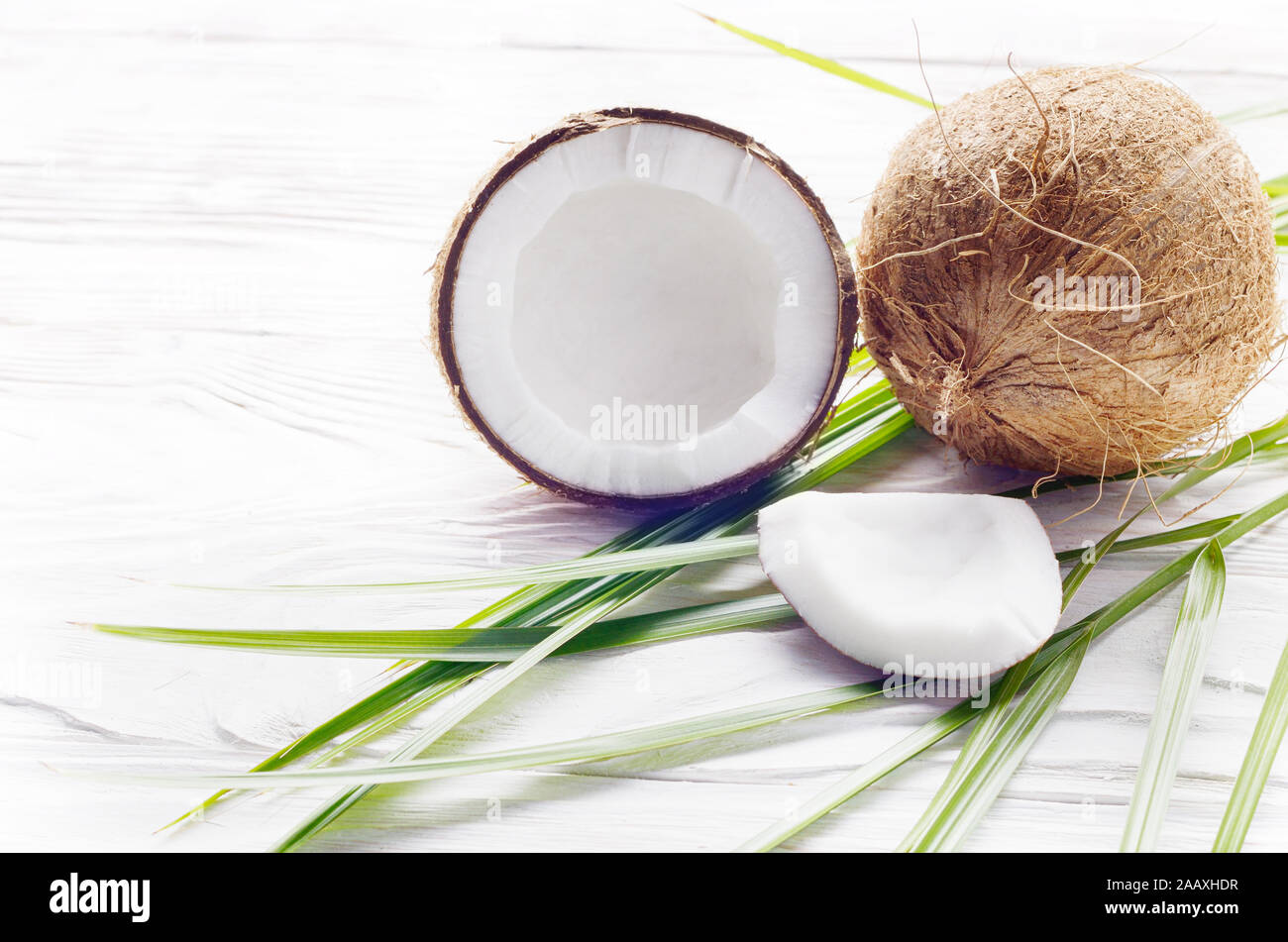 Coconut and shell pieces on white wooden table Stock Photo - Alamy