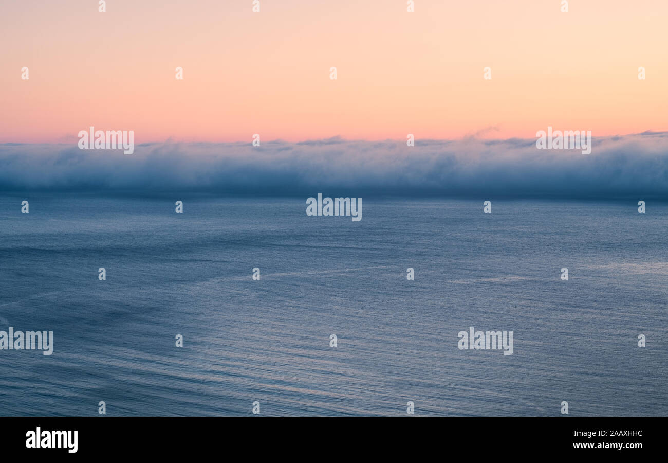 Atmospheric sunset with low clouds and calm sea at summer evening in ...