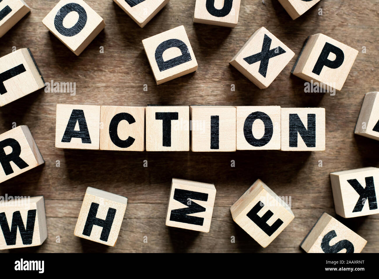 Letter block with word action on wood background with another alphabet ...