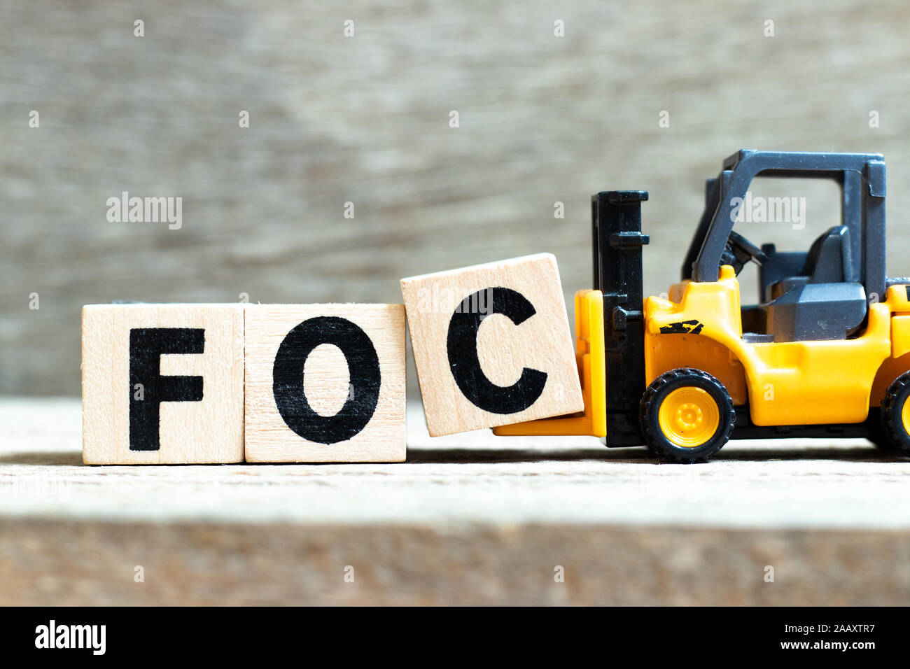 Toy forklift hold letter block c to complete word FOC (Abbreviation of ...