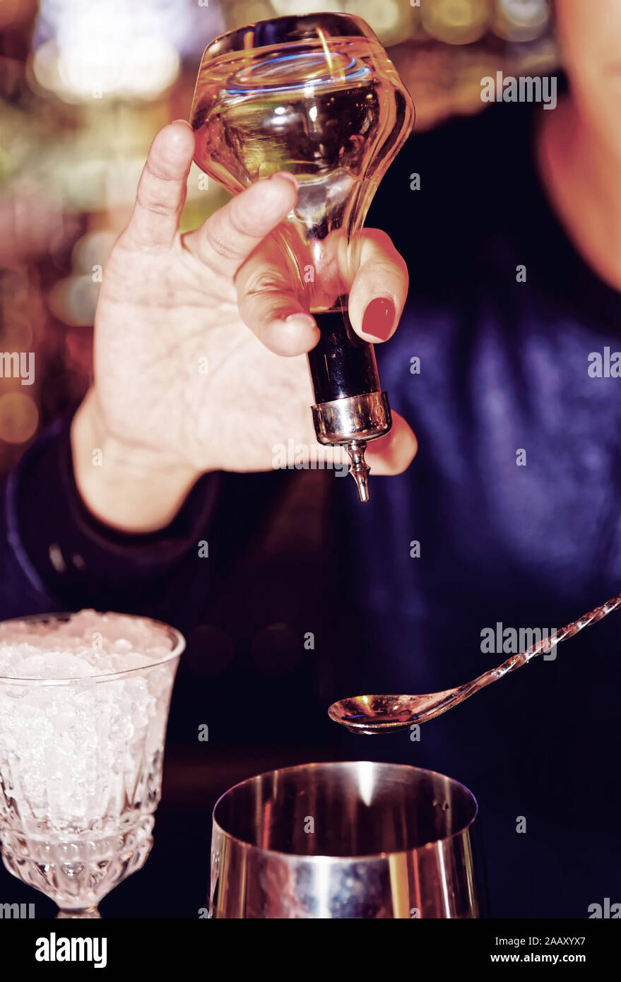 Bartender is adding some drops of bitter to shaker, toned Stock Photo - Alamy