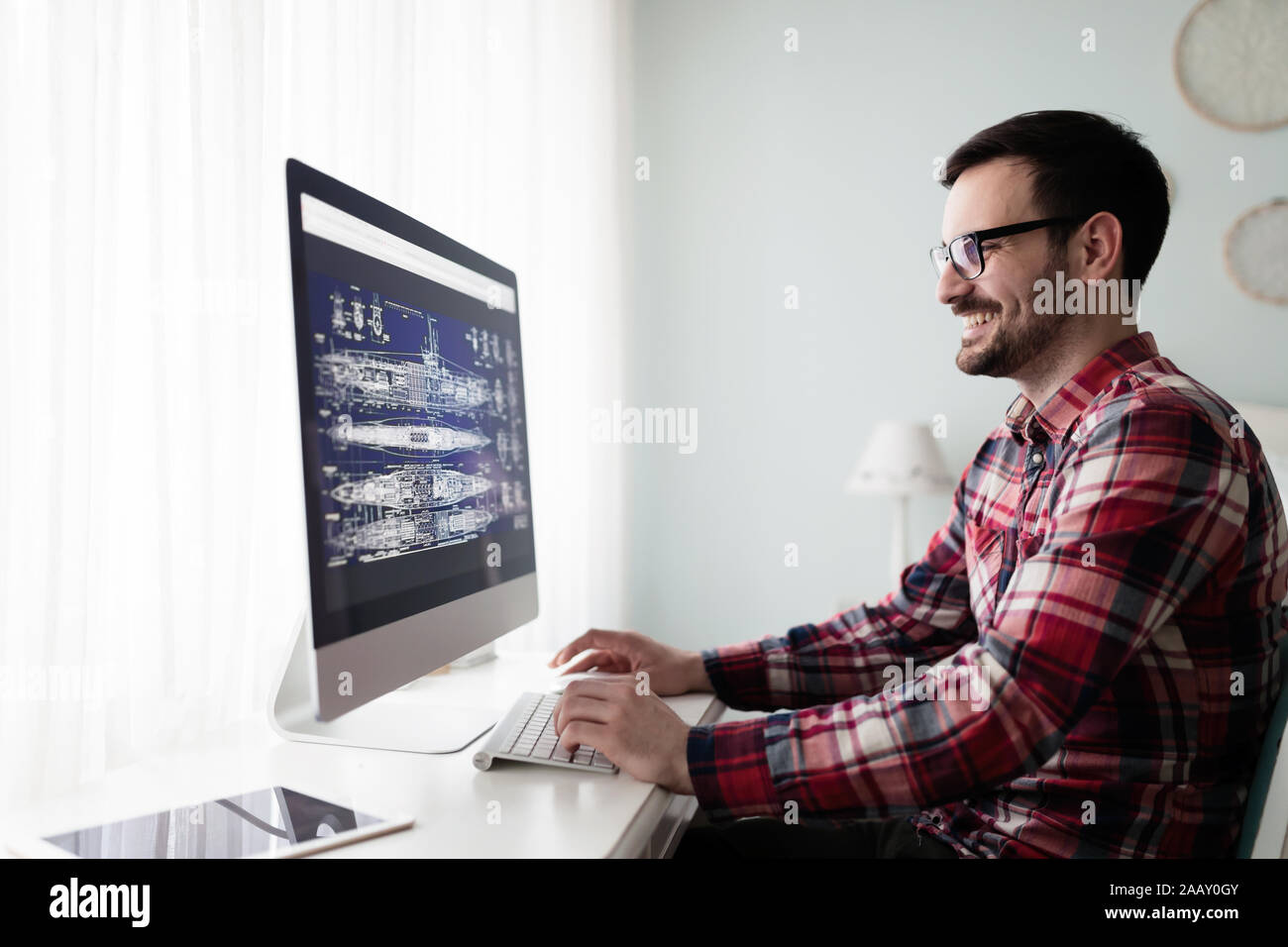 Cheerful graphic designer working from hi-res stock photography and ...