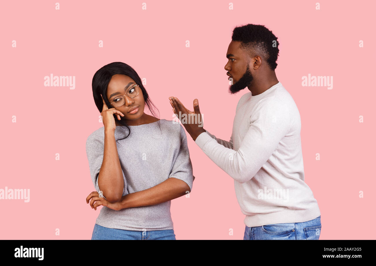 Black couple fighting over pink studio background Stock Photo - Alamy