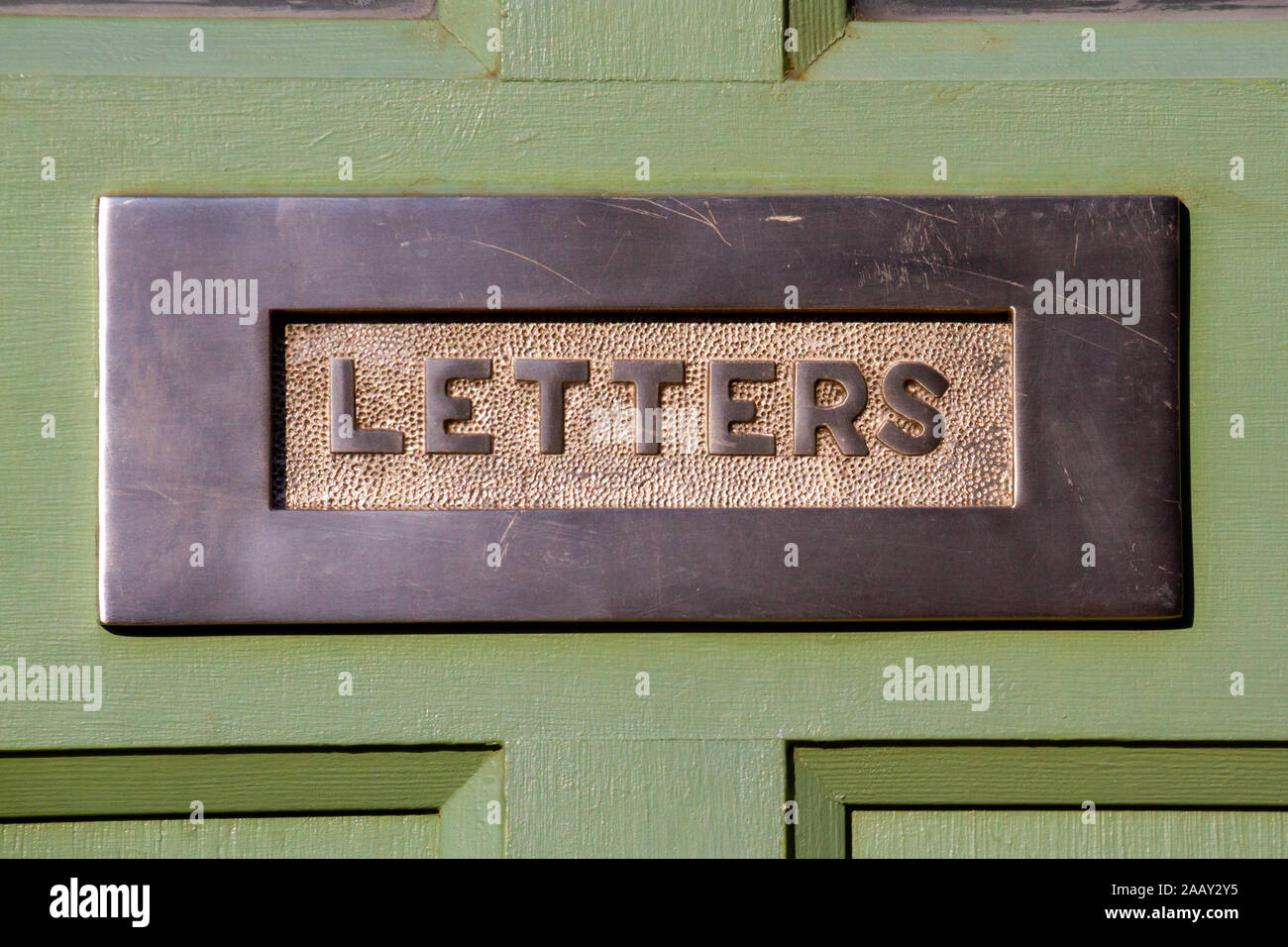 Vintage letterbox in a wooden front door with the word letters written ...