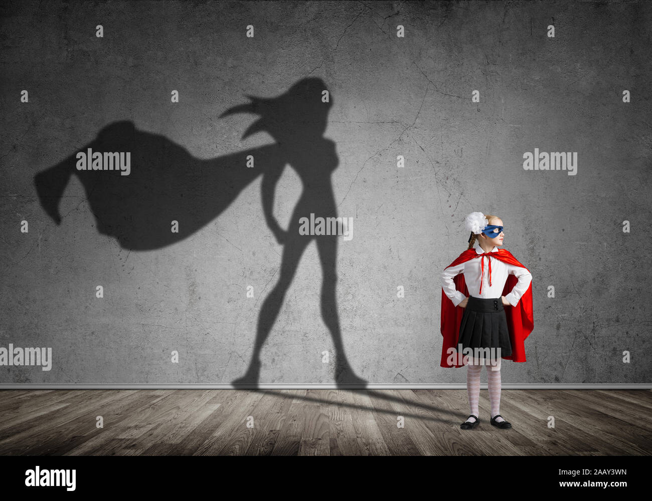 Girl power concept with cute kid guardian and shadow at wall. Mixed ...