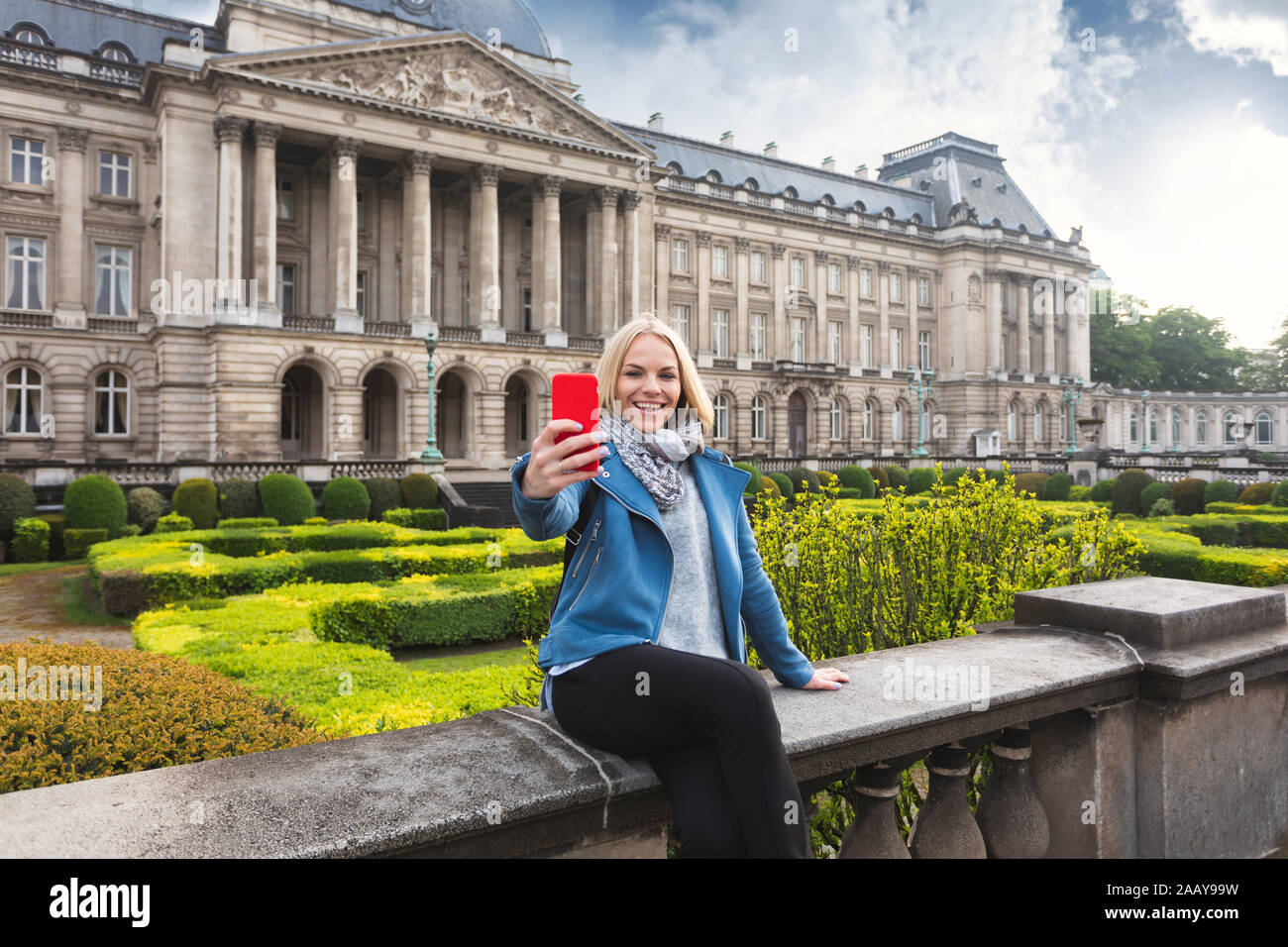 Woman posing against the backdrop of the Royal Palace in Brussels ...