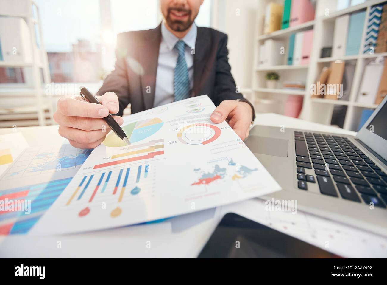 Fish eye view of unrecognizable businessman showing colorful data graph ...