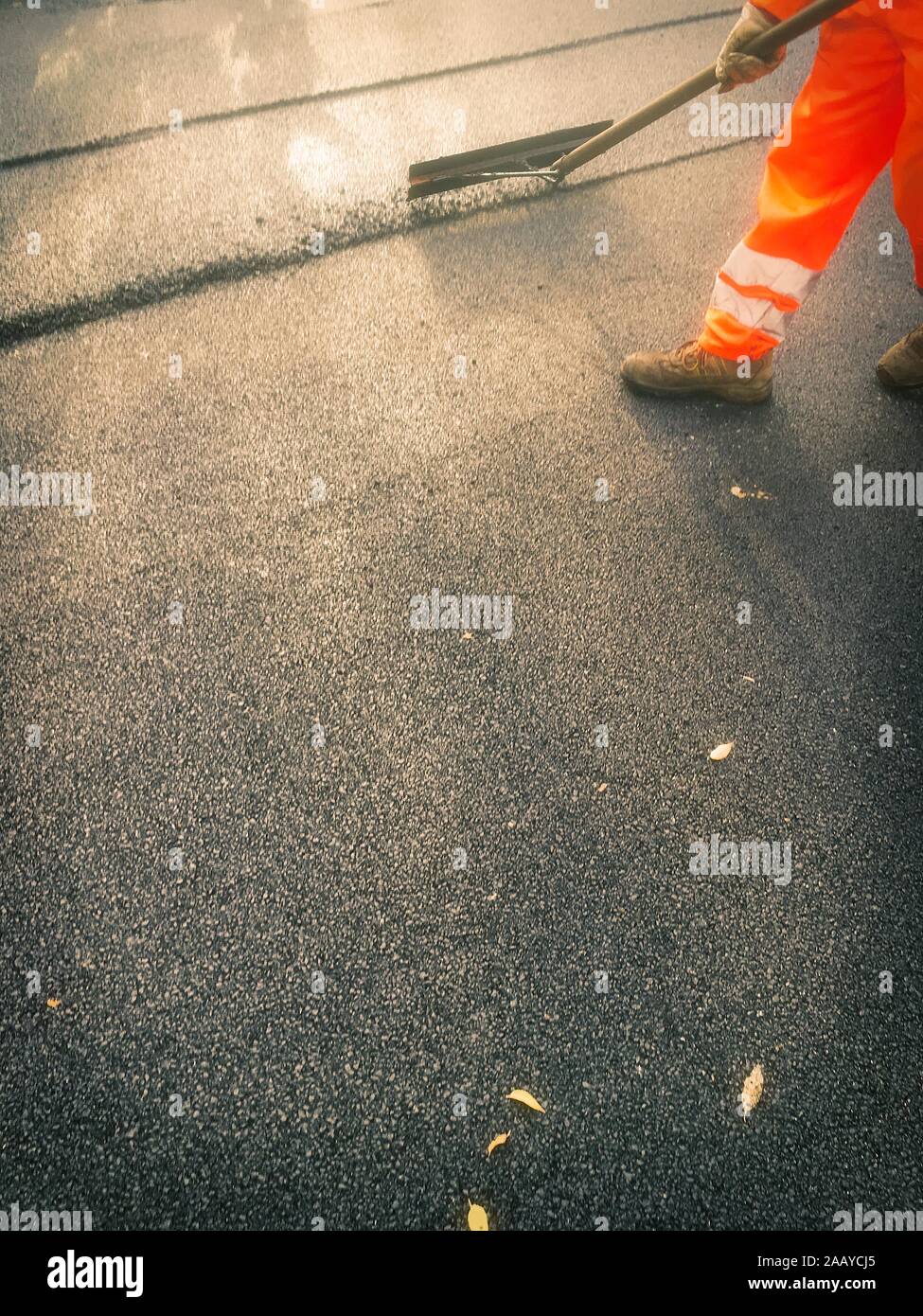 Worker with high visibility clothes while asphalt a road Stock Photo ...