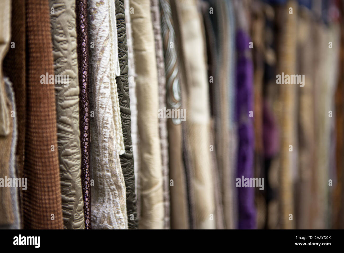 Colorful curtain samples hanging from hangers on a rail in a display in ...