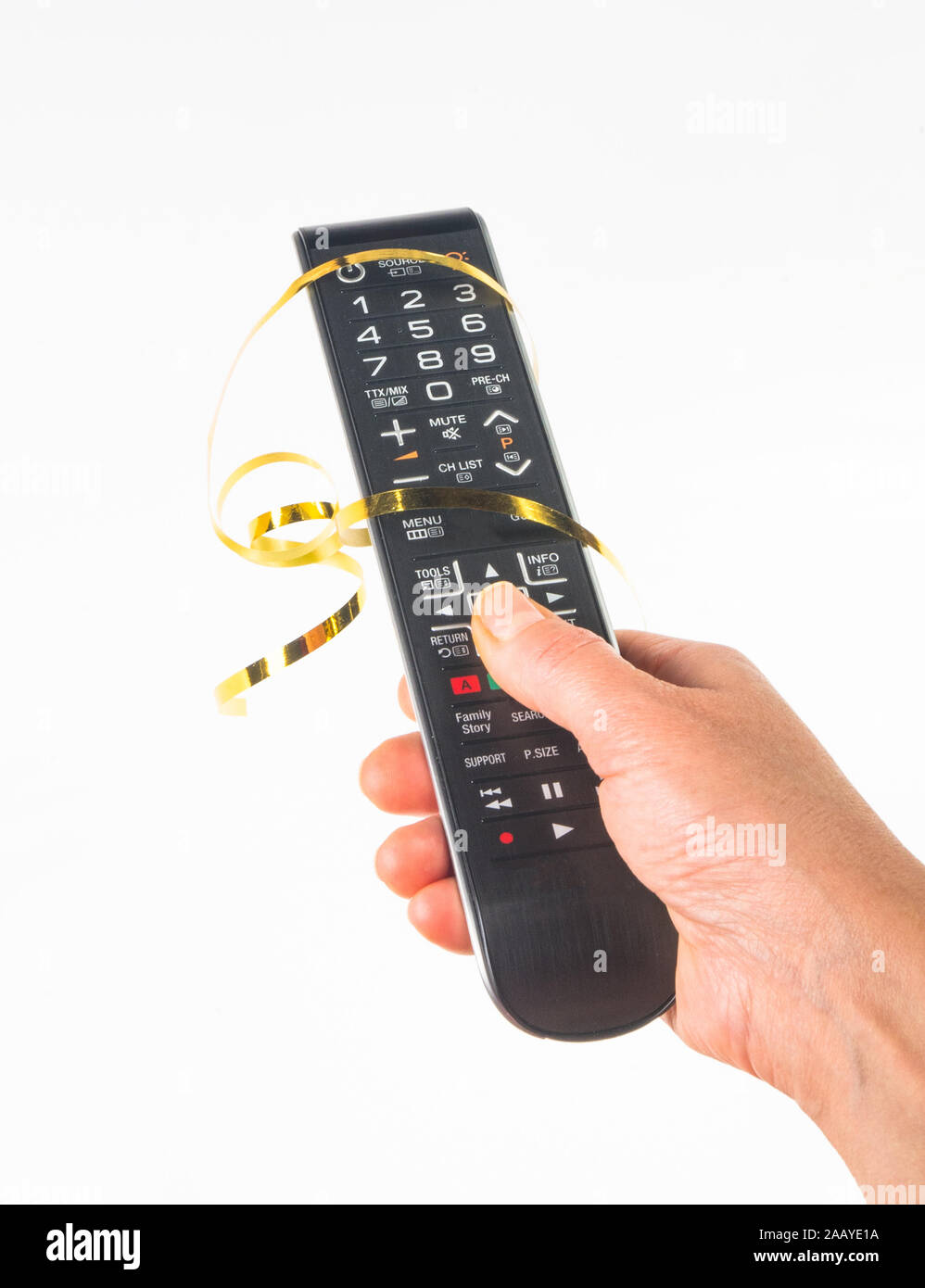 hand holding a remote control in a festive gold ribbon on white ...